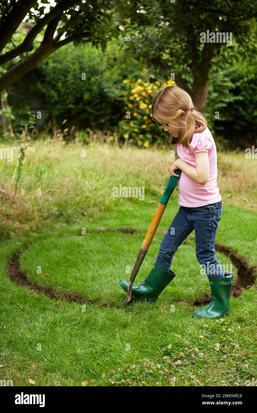 girl digging cirle in grass with shovel Stock Photo - Alamy