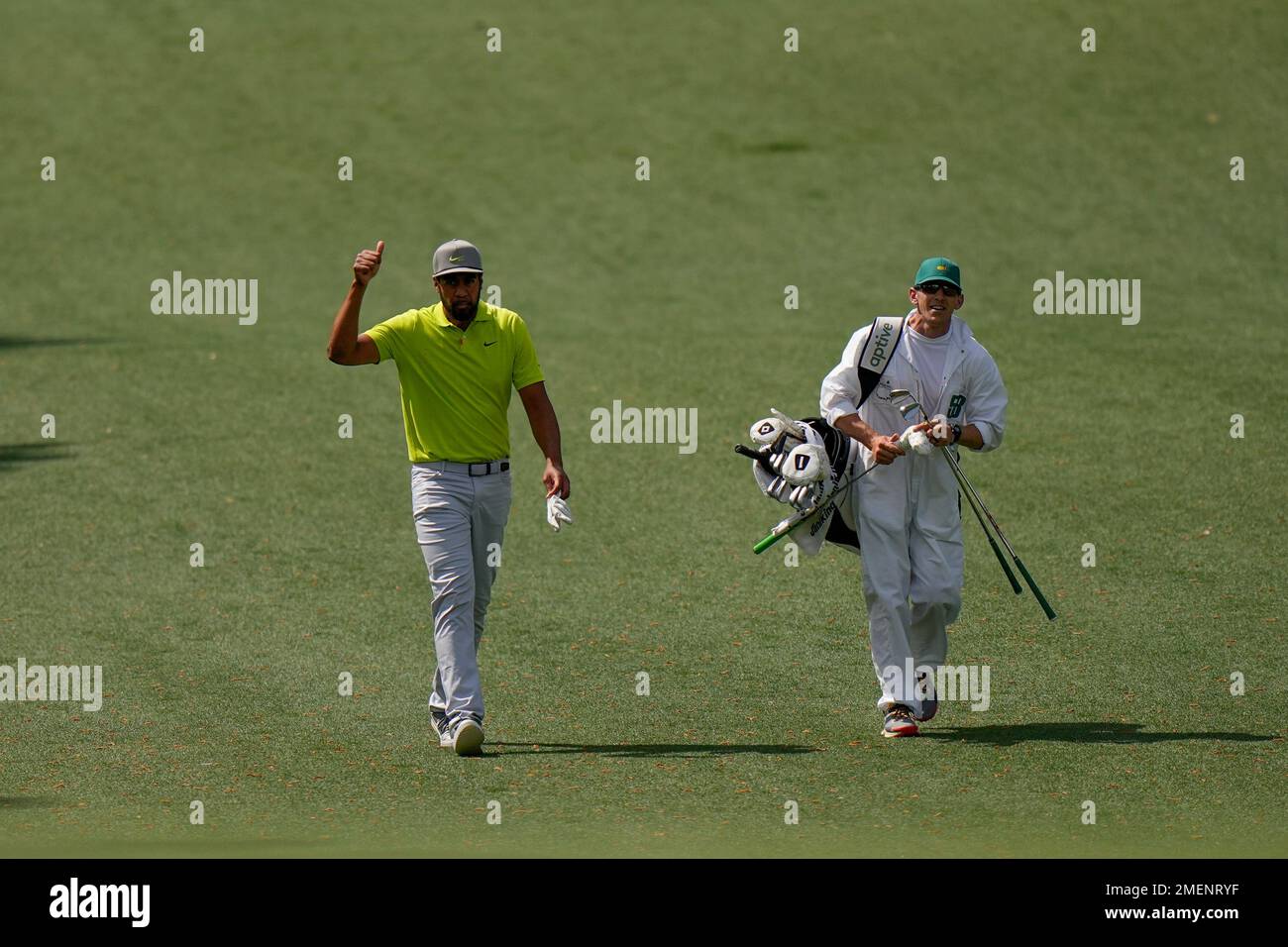 Tony Finau gives the thumbs up as he walks up the seventh hole with his ...