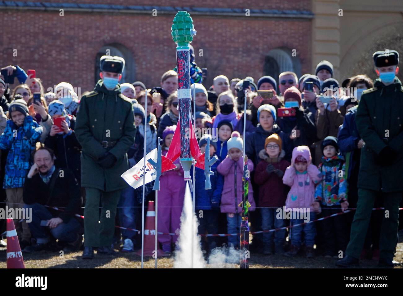 People watch the launch of a model rocket shaped as a grenade during a ...