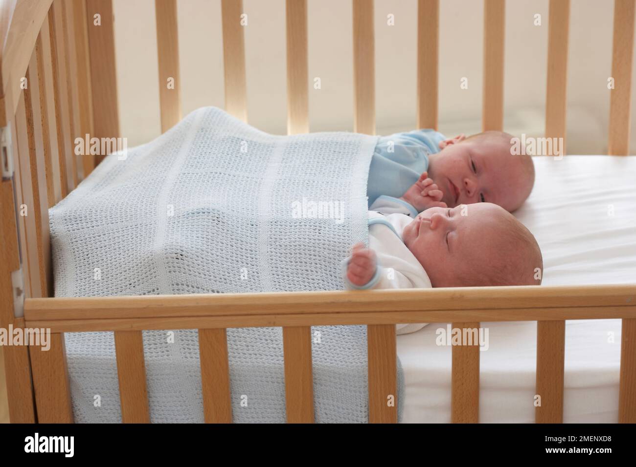 Twin girls asleep together in cot, close-up, 13 weeks Stock Photo - Alamy