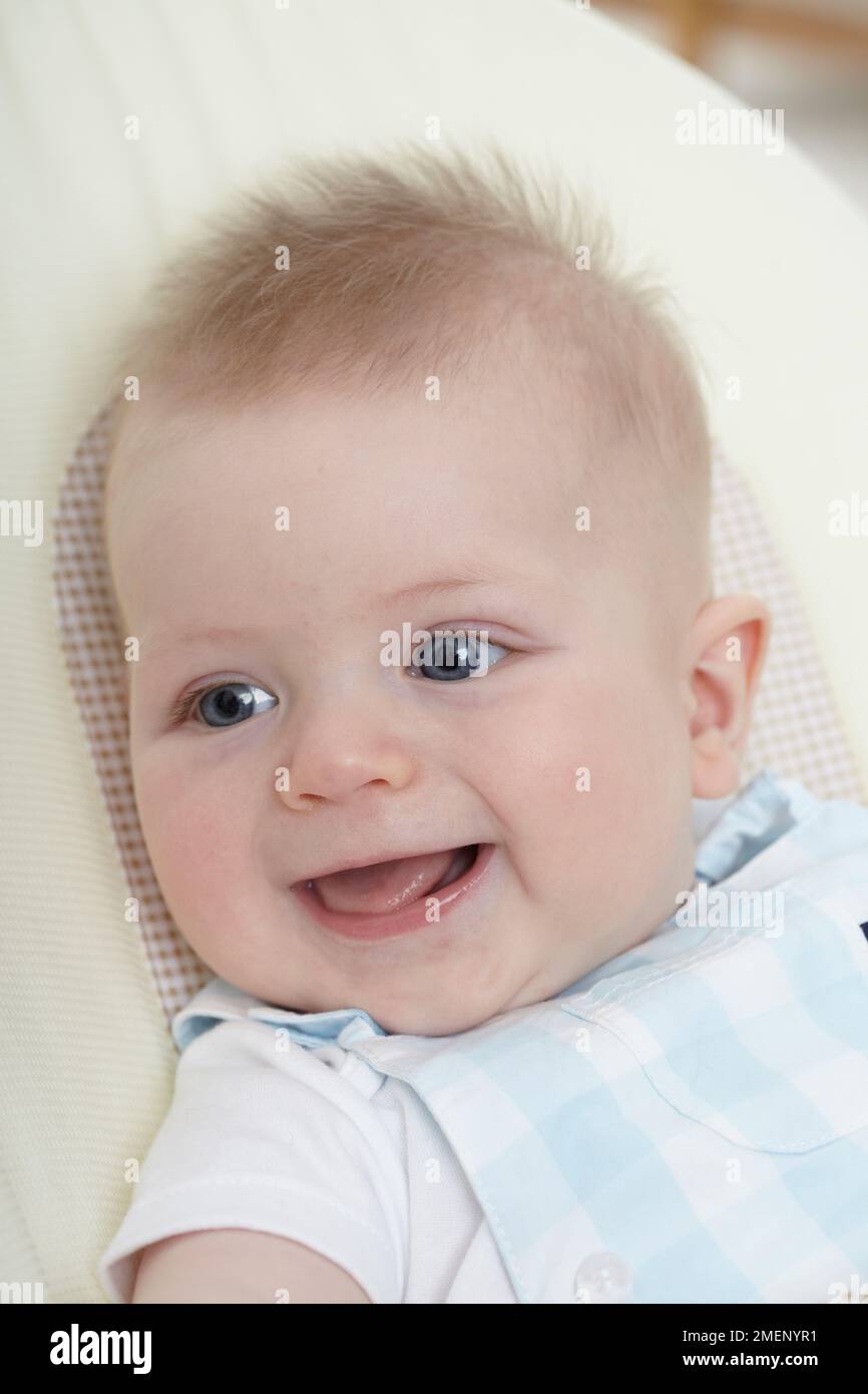 Smiling baby boy (5.5 months) sitting in bouncy chair, front view Stock ...