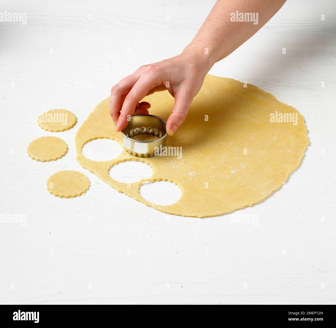 Using pastry cutter to cut shortcrust pastry tarts, close-up Stock ...