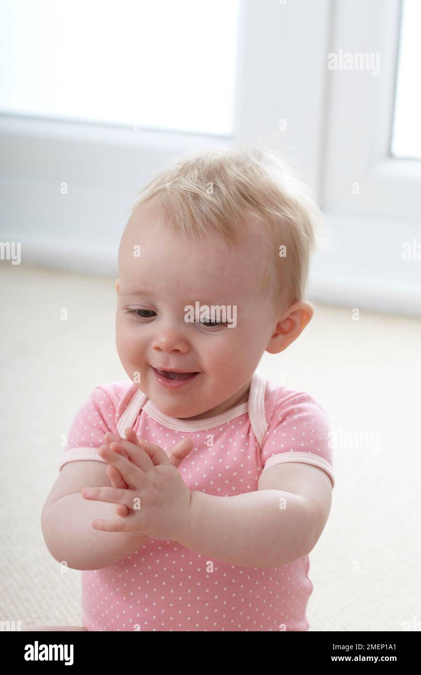 Baby girl (9 months) clapping her hands, front view Stock Photo - Alamy