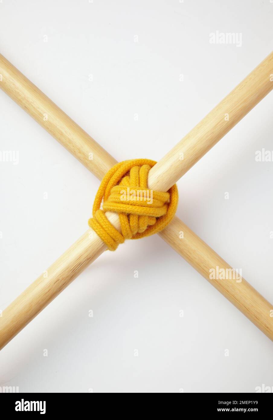 Diagonal Lashing, tied in yellow rope around two crossed wooden poles ...