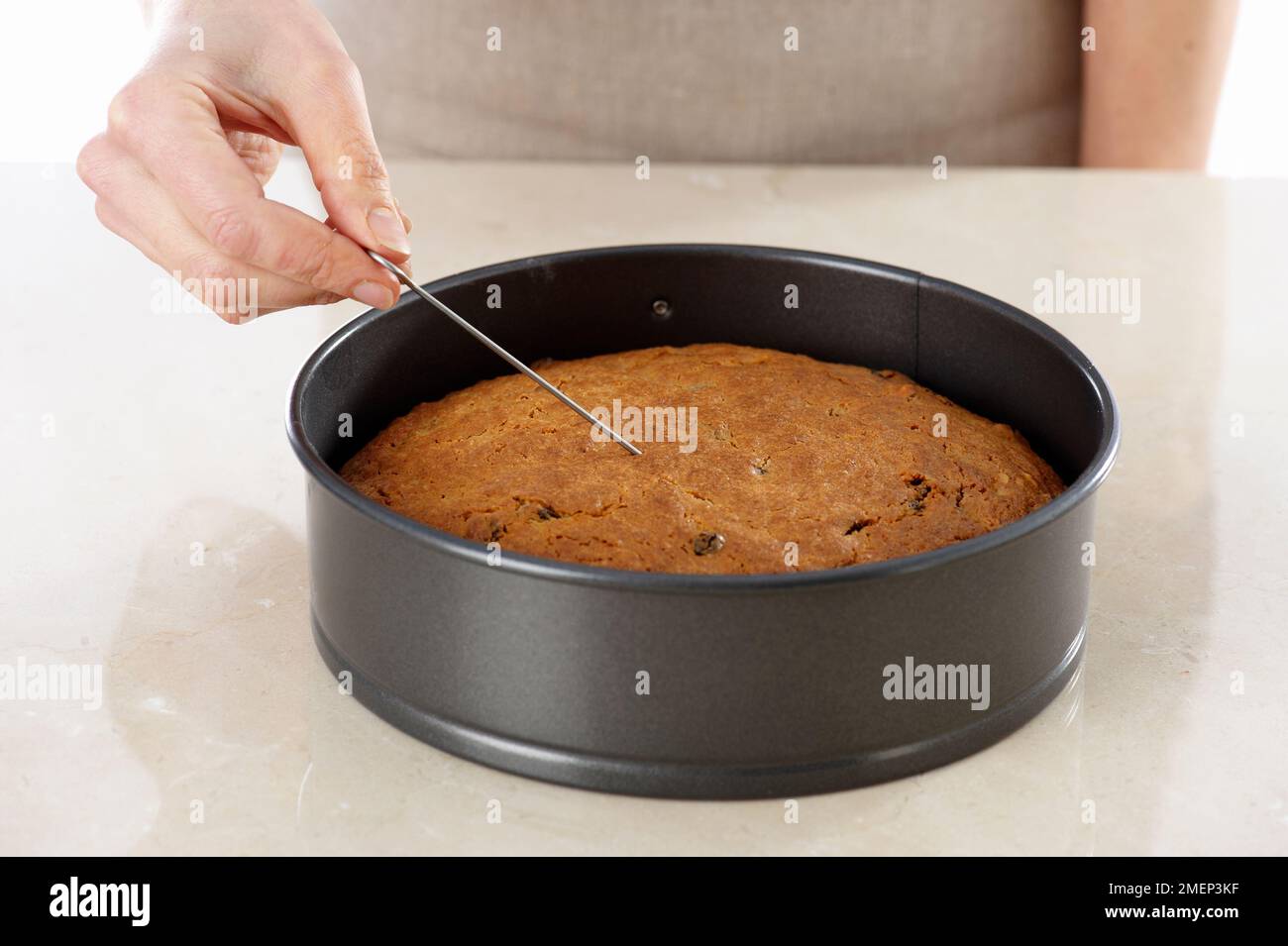 Carrot Cake, inserting skewer into cake to test if done Stock Photo - Alamy