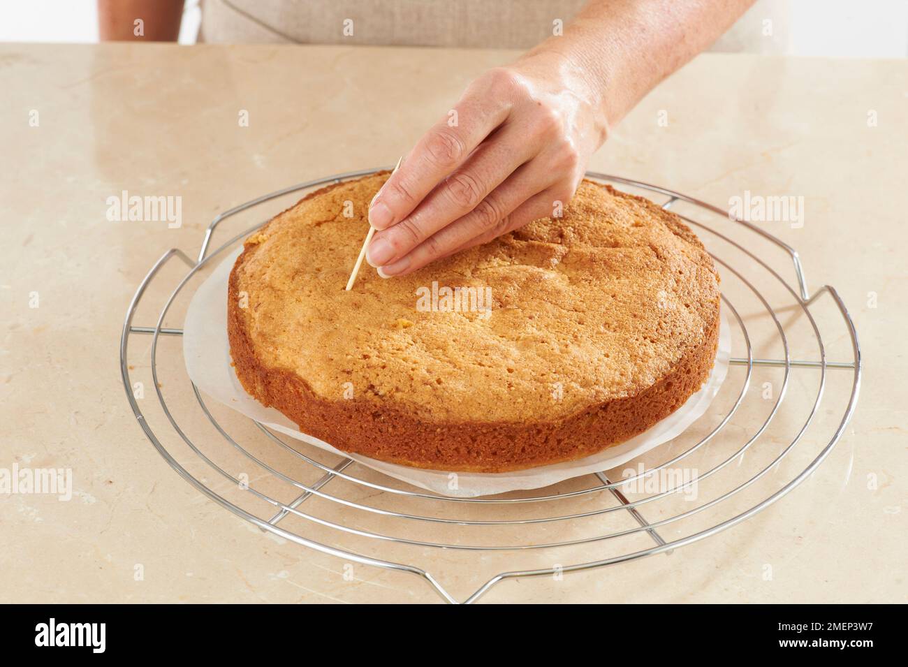Lemon Polenta Cake, using cocktail stick to poke holes in cake while ...