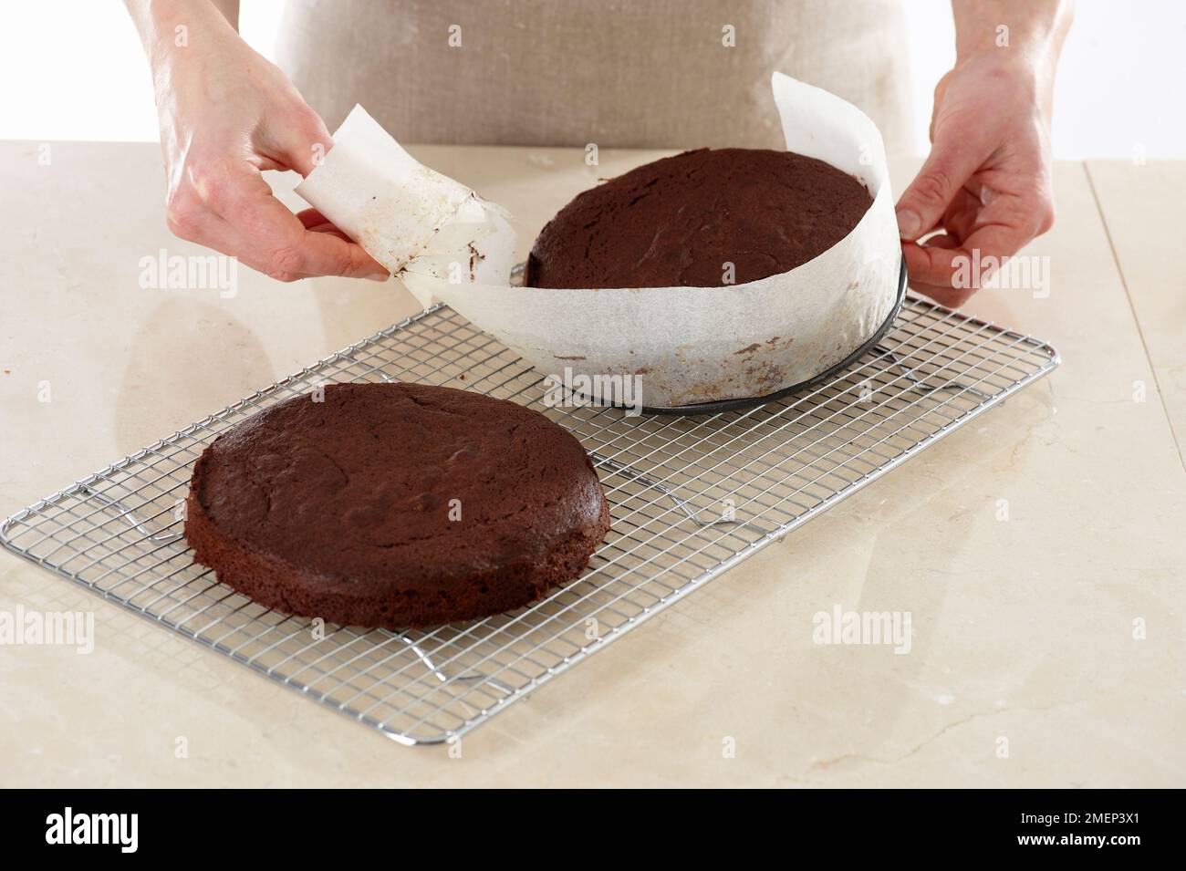 Chocolate Cake, removing the parchment paper from baked cake Stock ...