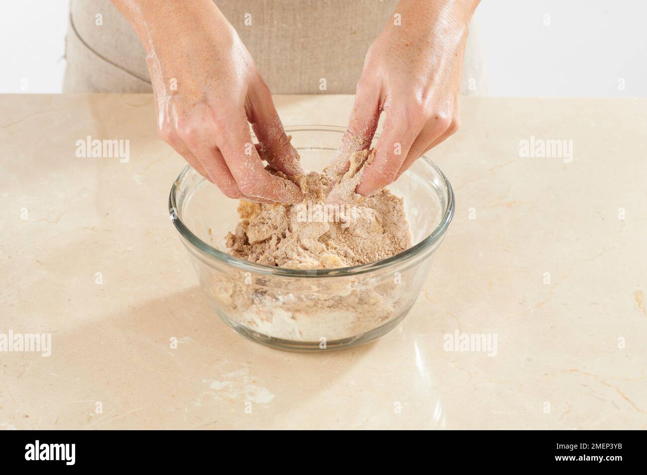 Making German Apple Cake, rubbing butter into streusel mixture Stock ...