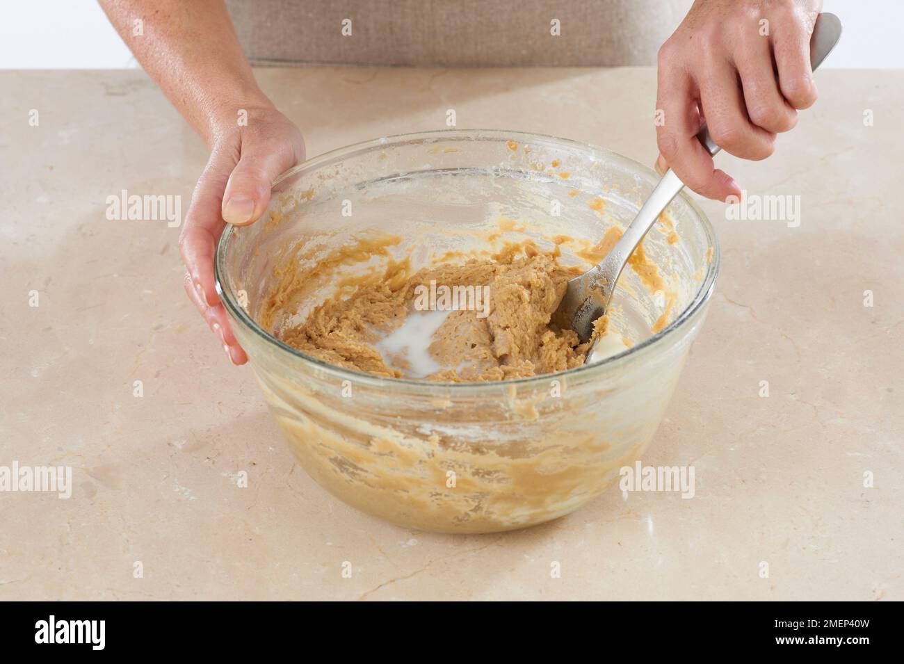 Making German Apple Cake, adding milk to batter and mixing in Stock ...