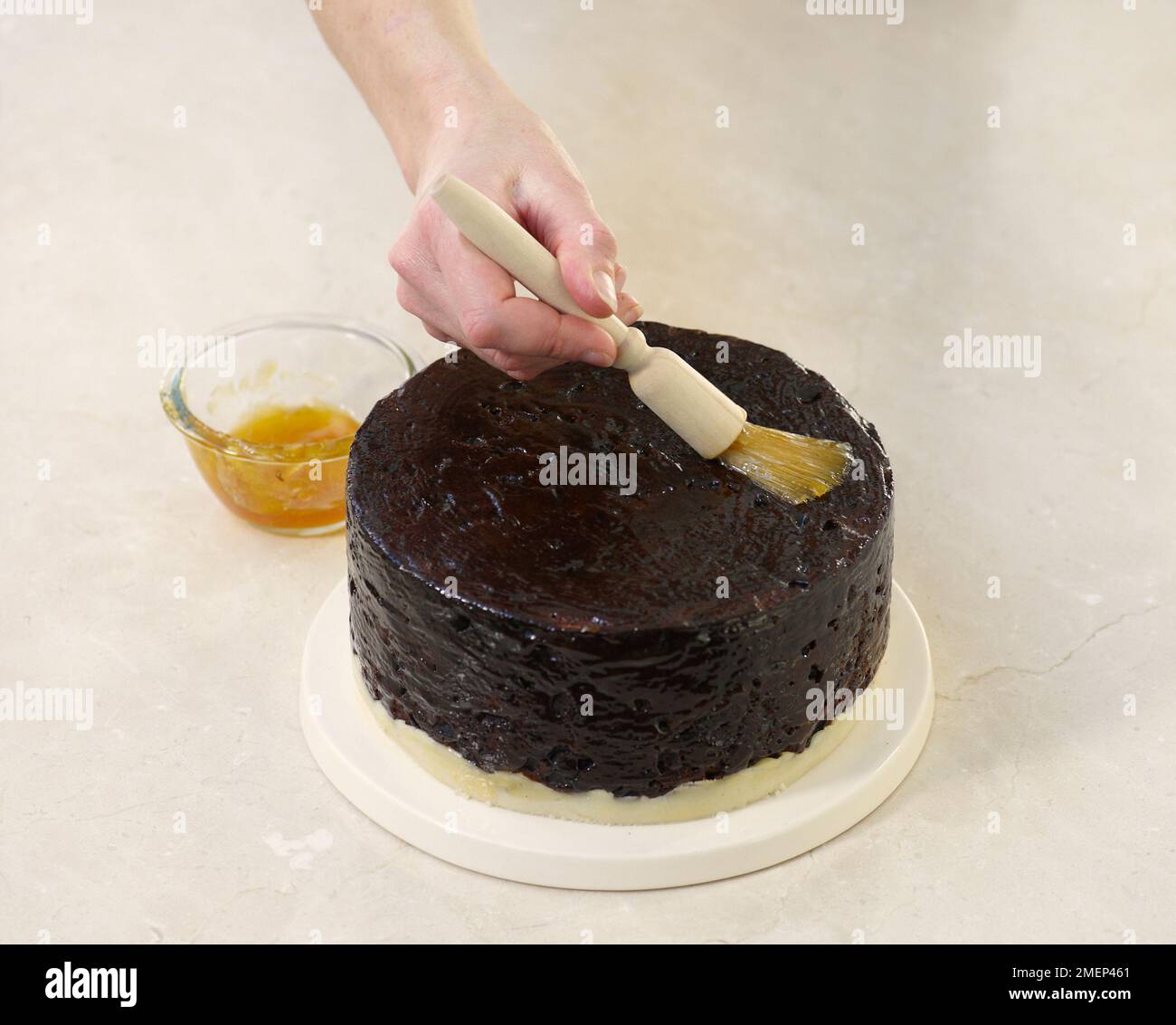 Rich Fruit Cake, brushing jam over warm cake Stock Photo - Alamy