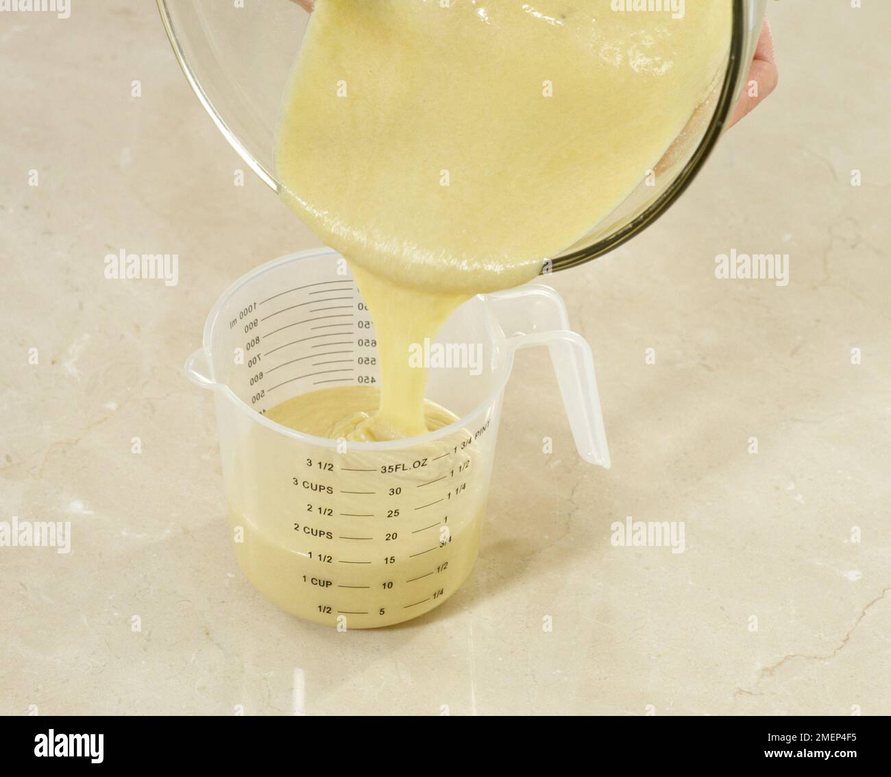 Making Vanilla Cream Cupcakes, pouring cake batter into a jug Stock ...