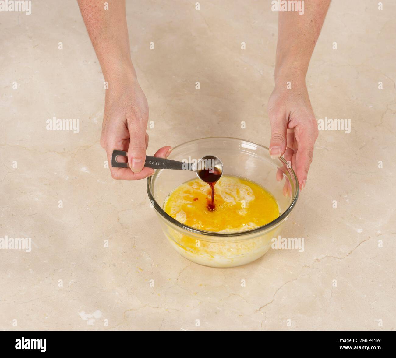 Making Lemon and Blueberry Muffins, adding vanilla extract to mixture ...