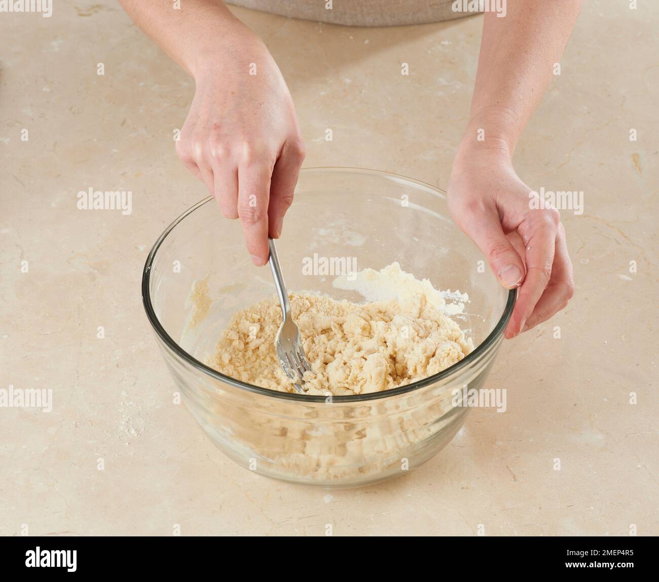 Using fork in scone ingredients in glass mixing bowl Stock Photo - Alamy