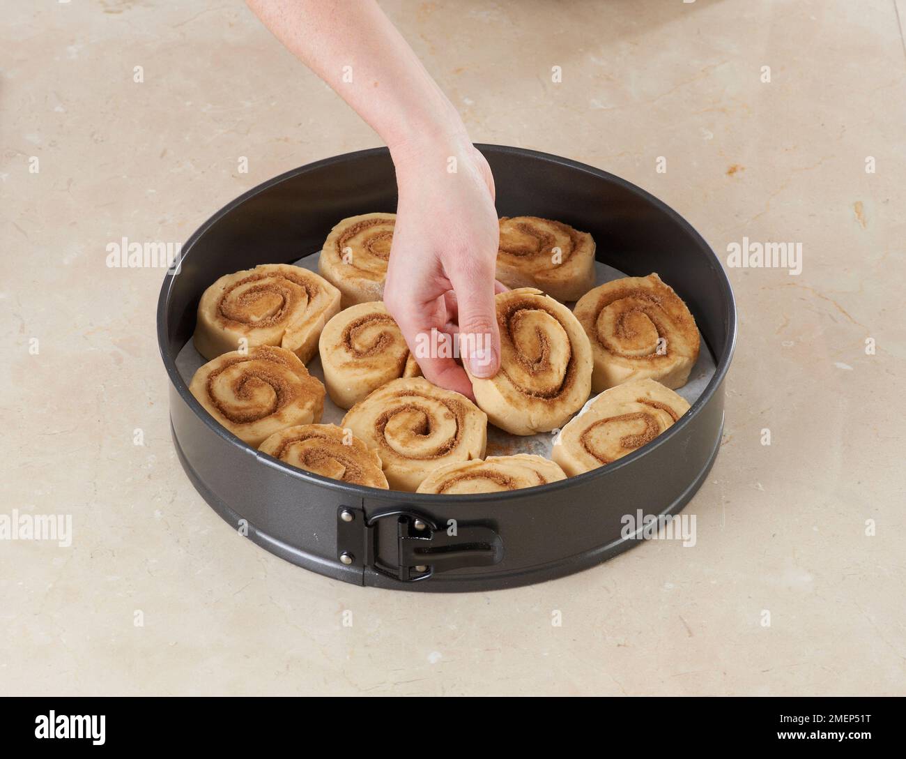 Cinnamon Rolls, placing pieces in baking tin Stock Photo - Alamy