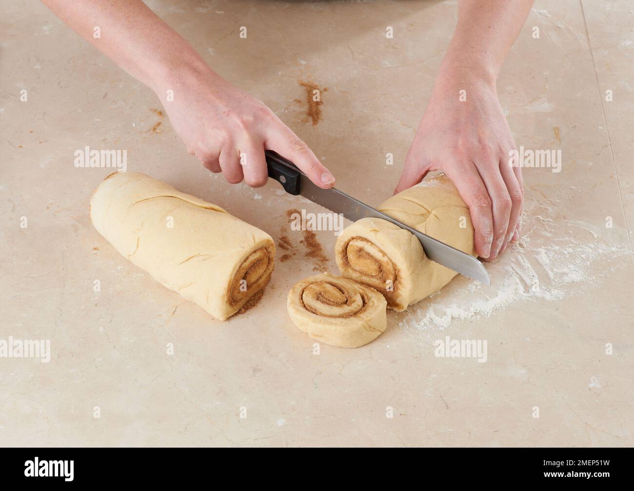 Cinnamon Rolls, cutting rolled up dough into equal pieces using ...