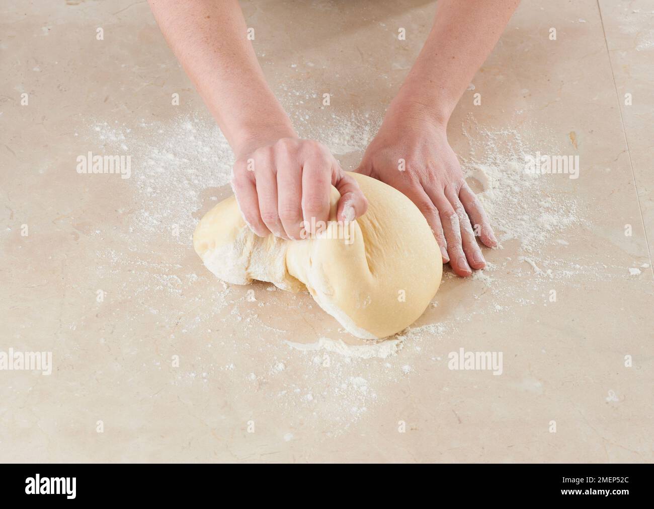 Making Cinnamon Rolls, kneading risen dough on floured surface Stock ...