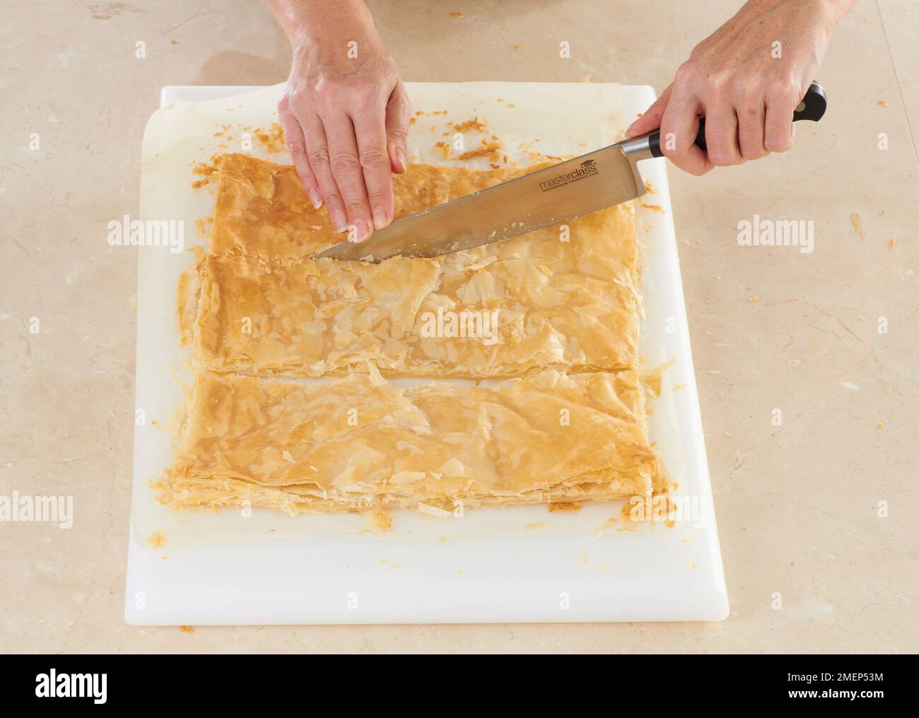 Making Millefeuilles, cutting trimmed pastry lengthways into equal ...