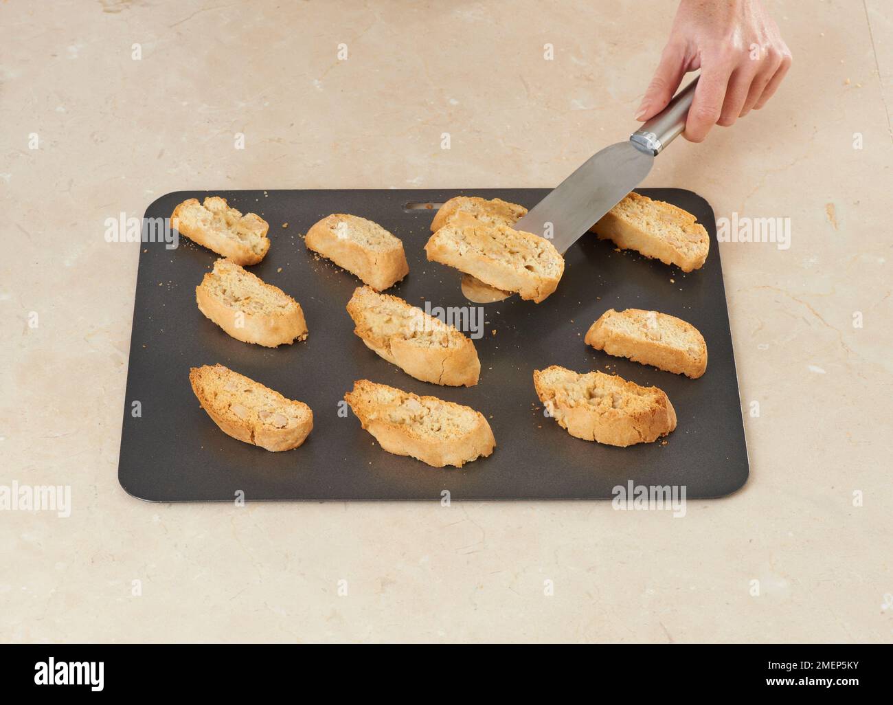 Using spatula to lift Biscotti from baking tray Stock Photo - Alamy