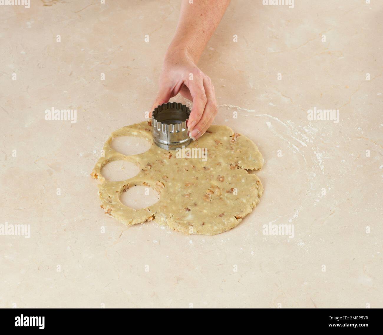 Making Stilton and Walnut Biscuits, cutting out biscuits using round ...