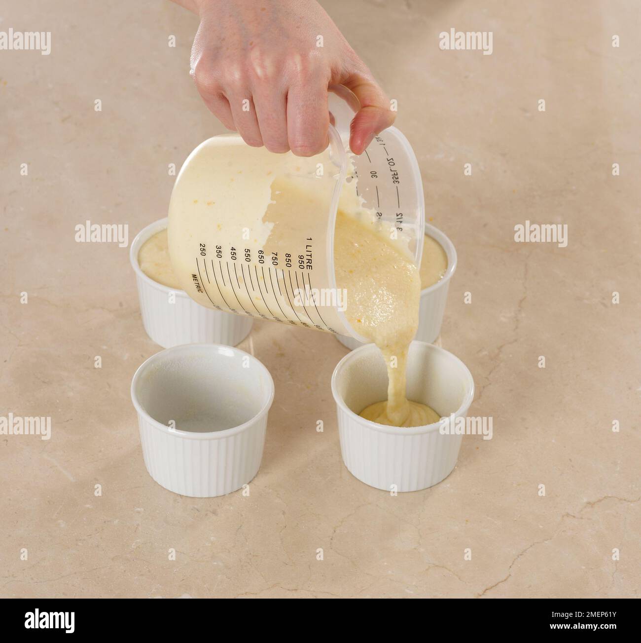 Making orange souffles, pouring mixture into ramekins Stock Photo - Alamy