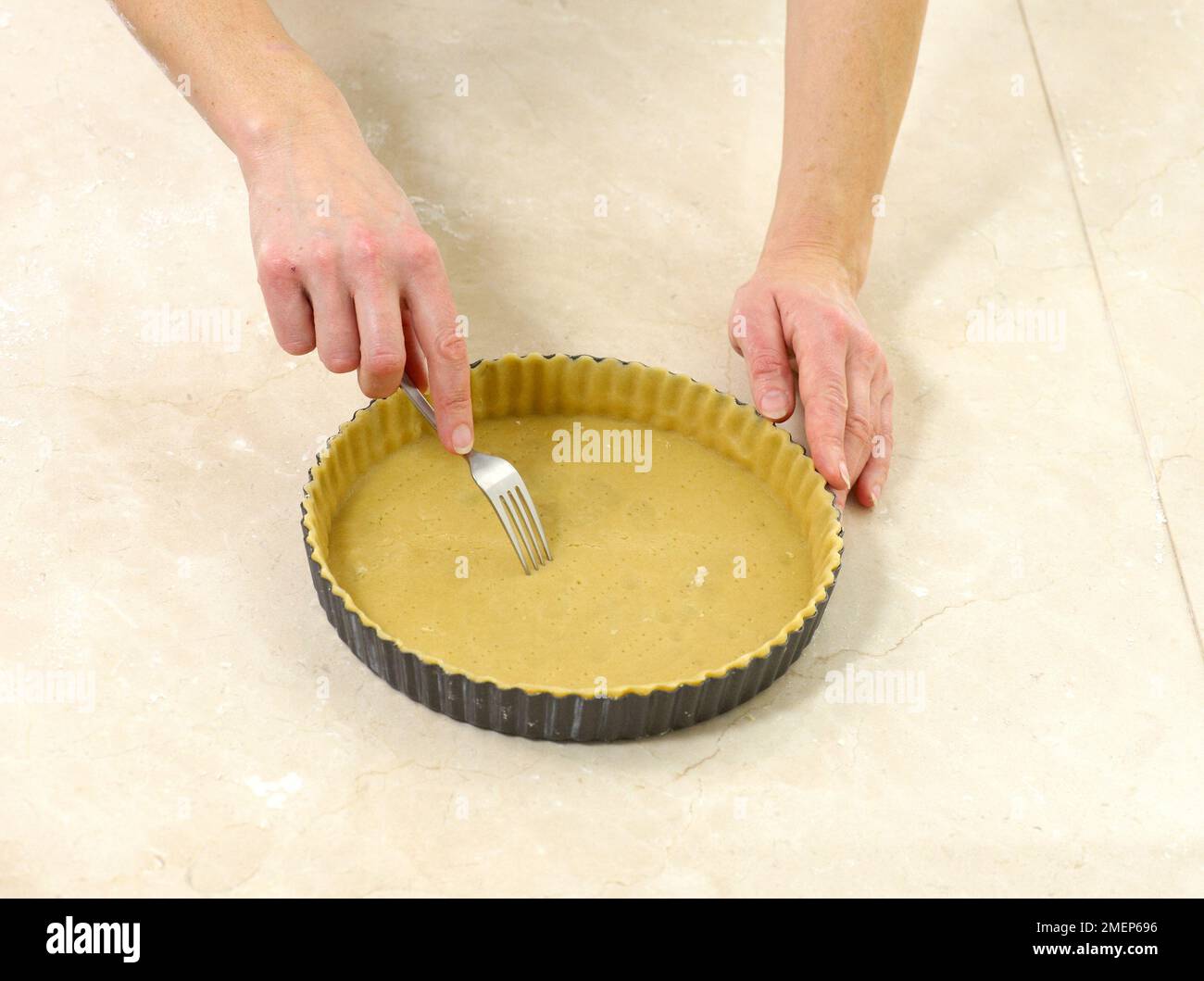 Making Normandy Pear Tart, pricking pastry base with fork Stock Photo ...