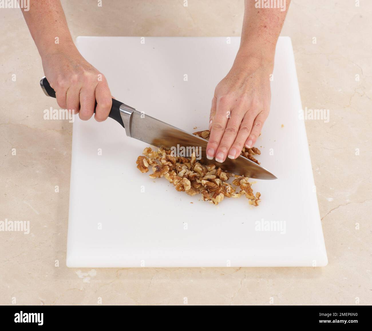 Coarsely chopping walnuts with a large knife Stock Photo - Alamy