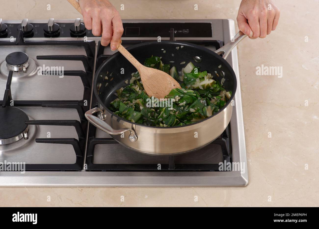Adding roughly chopped Swiss Chard to pan and frying together with ...