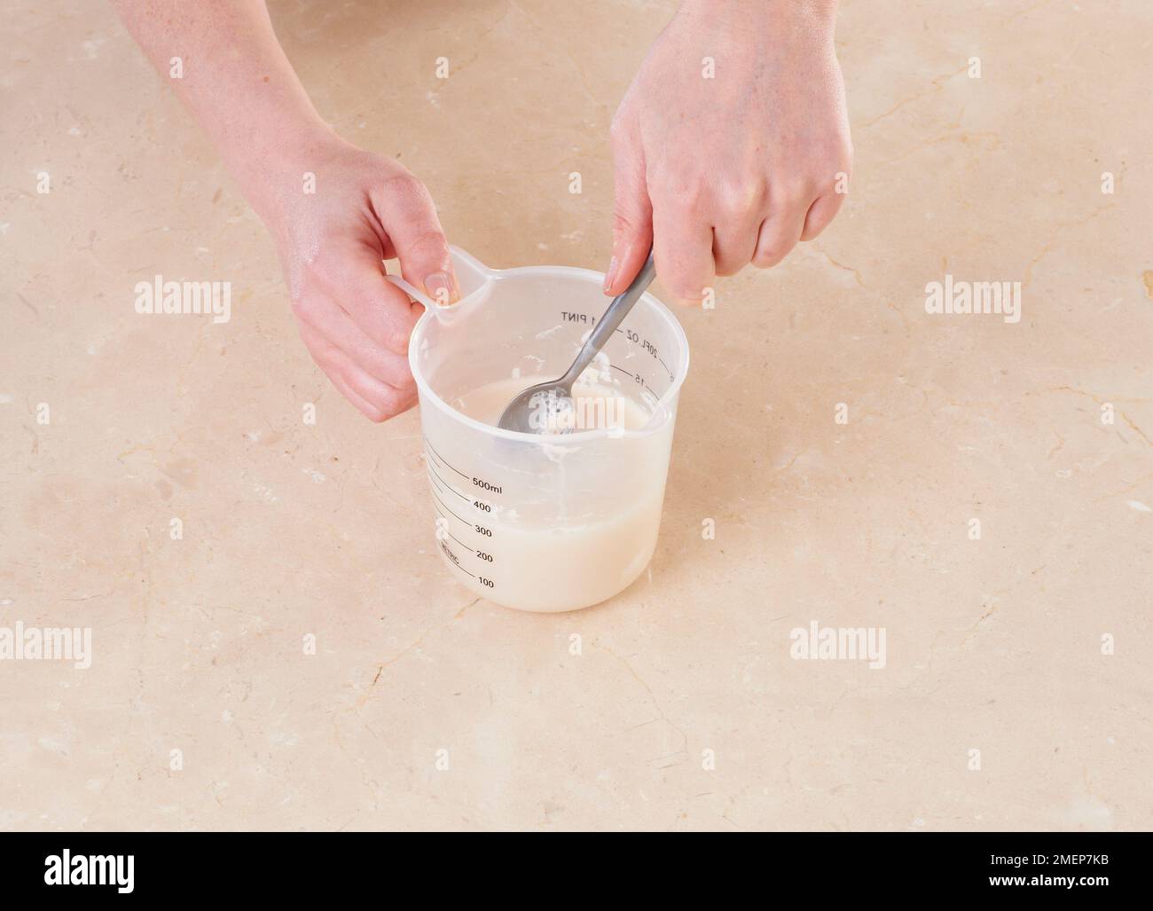 Dissolving yeast in plastic measuring jug with spoon Stock Photo - Alamy