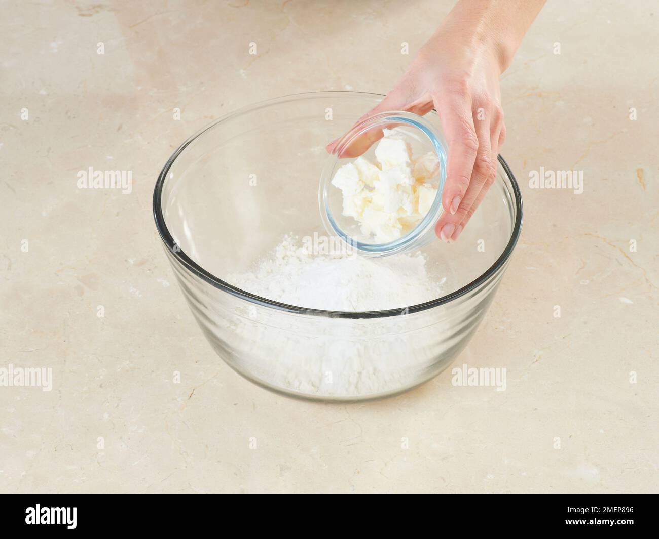 Adding bowl of lard to tortilla ingredients in glass mixing bowl using ...