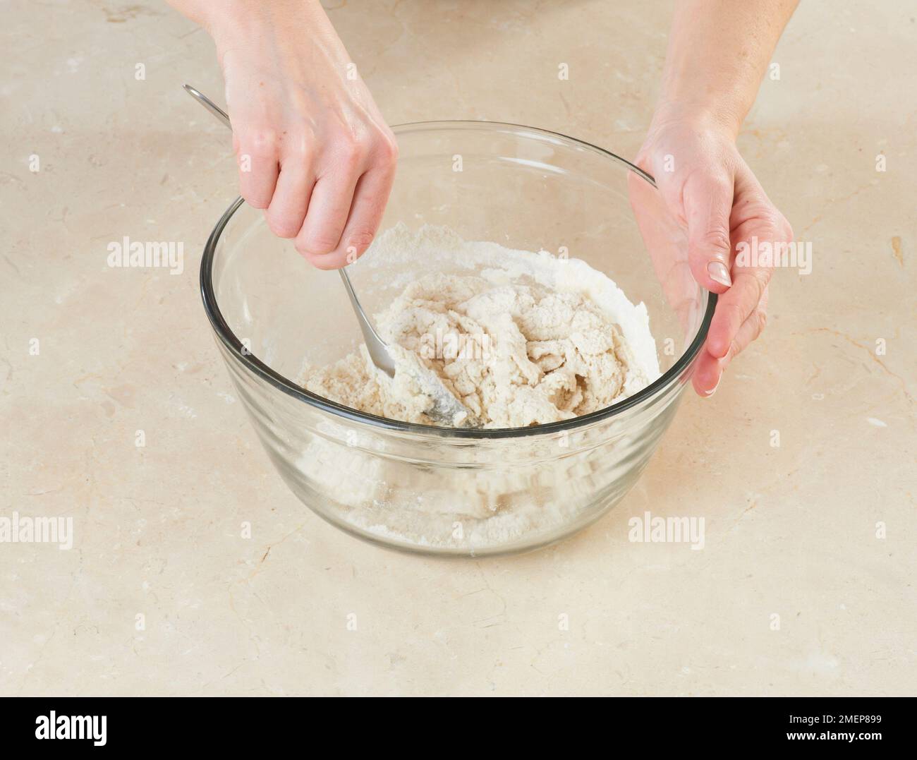 Mixing tortilla ingredients in glass mixing bowl using spoon Stock ...