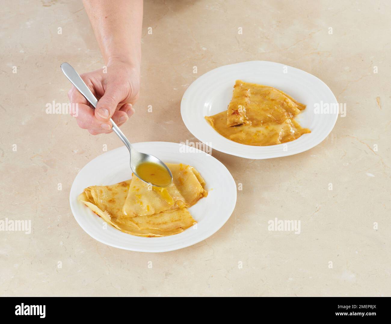 Making Crepes Suzette, spooning sauce over them Stock Photo - Alamy