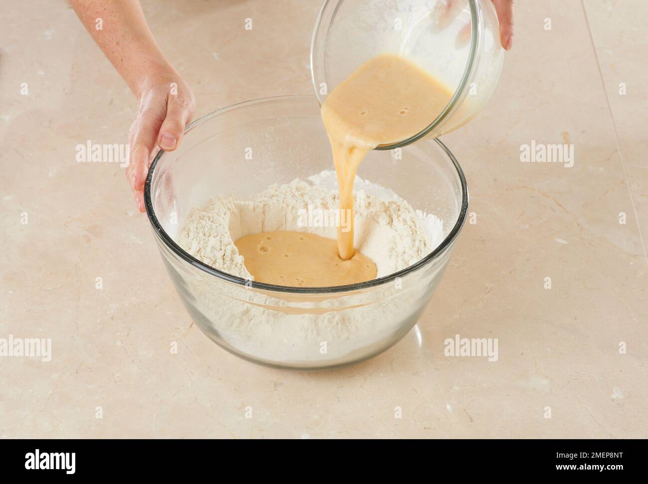 Making Brioche des rois, making a well in flour and pouring in eggs and ...