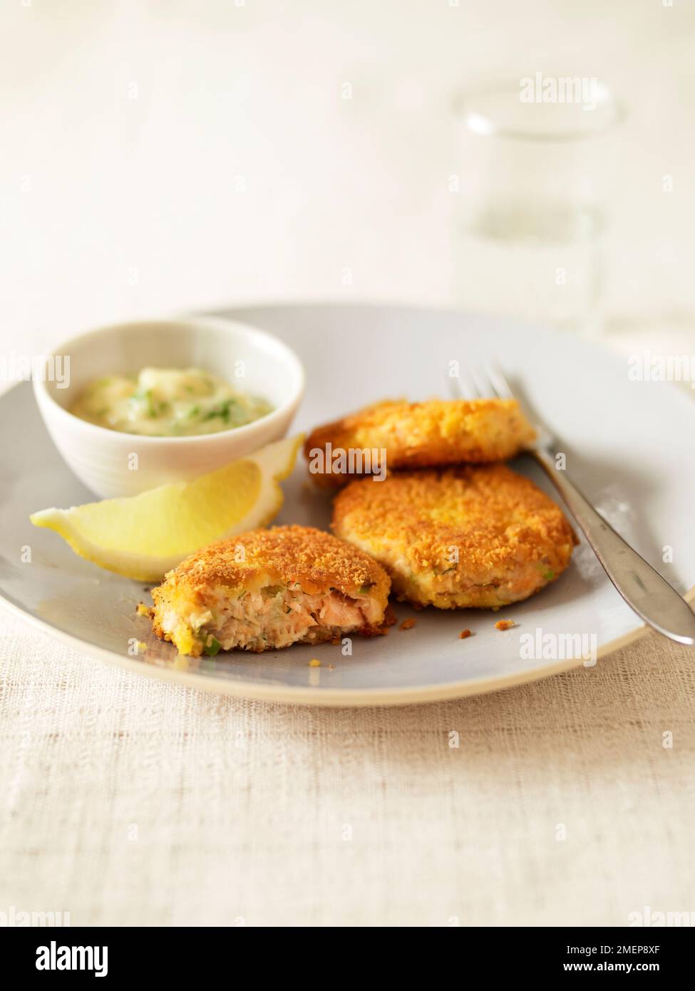 Gluten free mini fish cakes served on plate with slice of lemon and dip ...