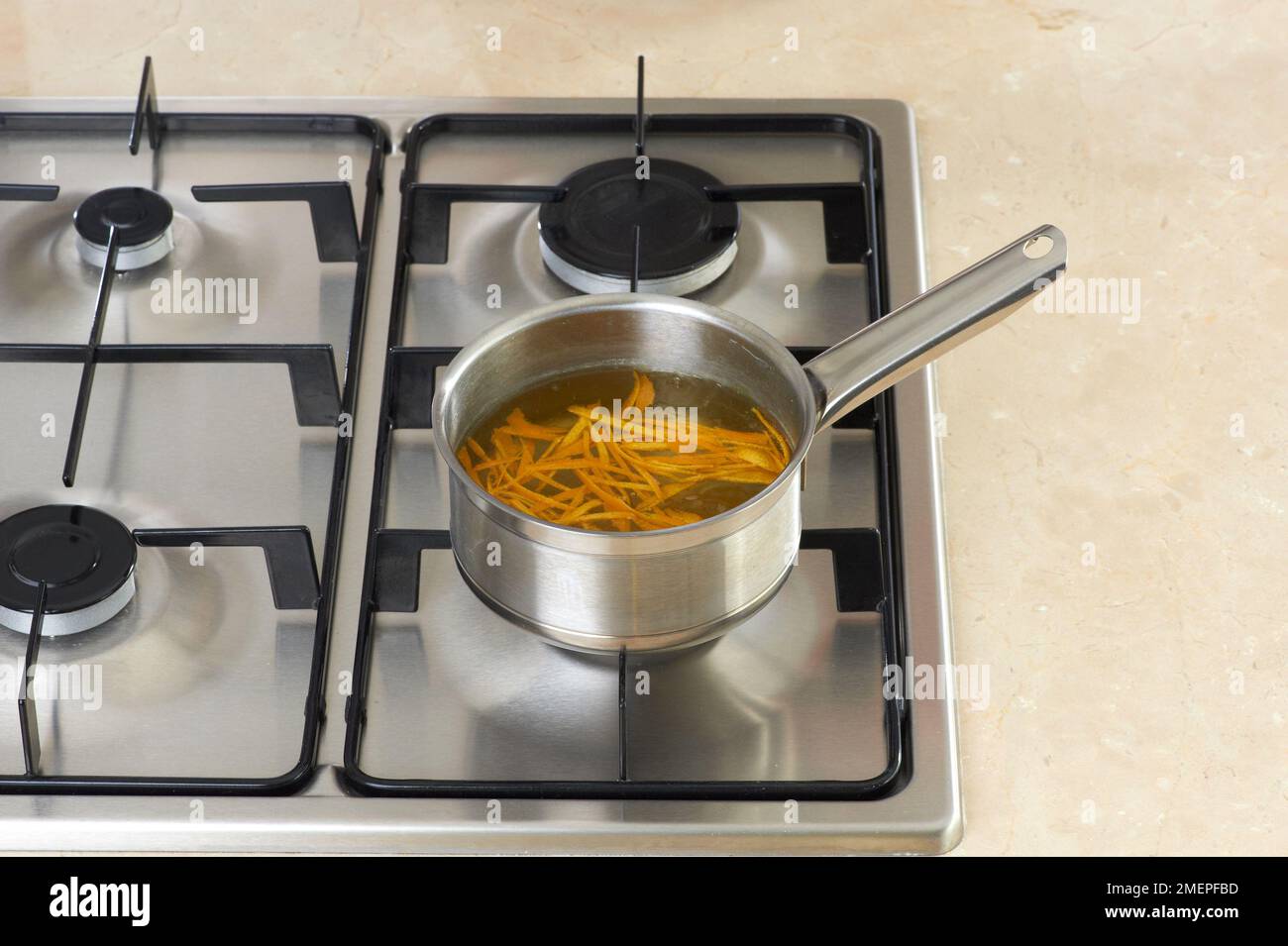 Julienned orange strips in pan of boiling water, making Crepes Suzette ...