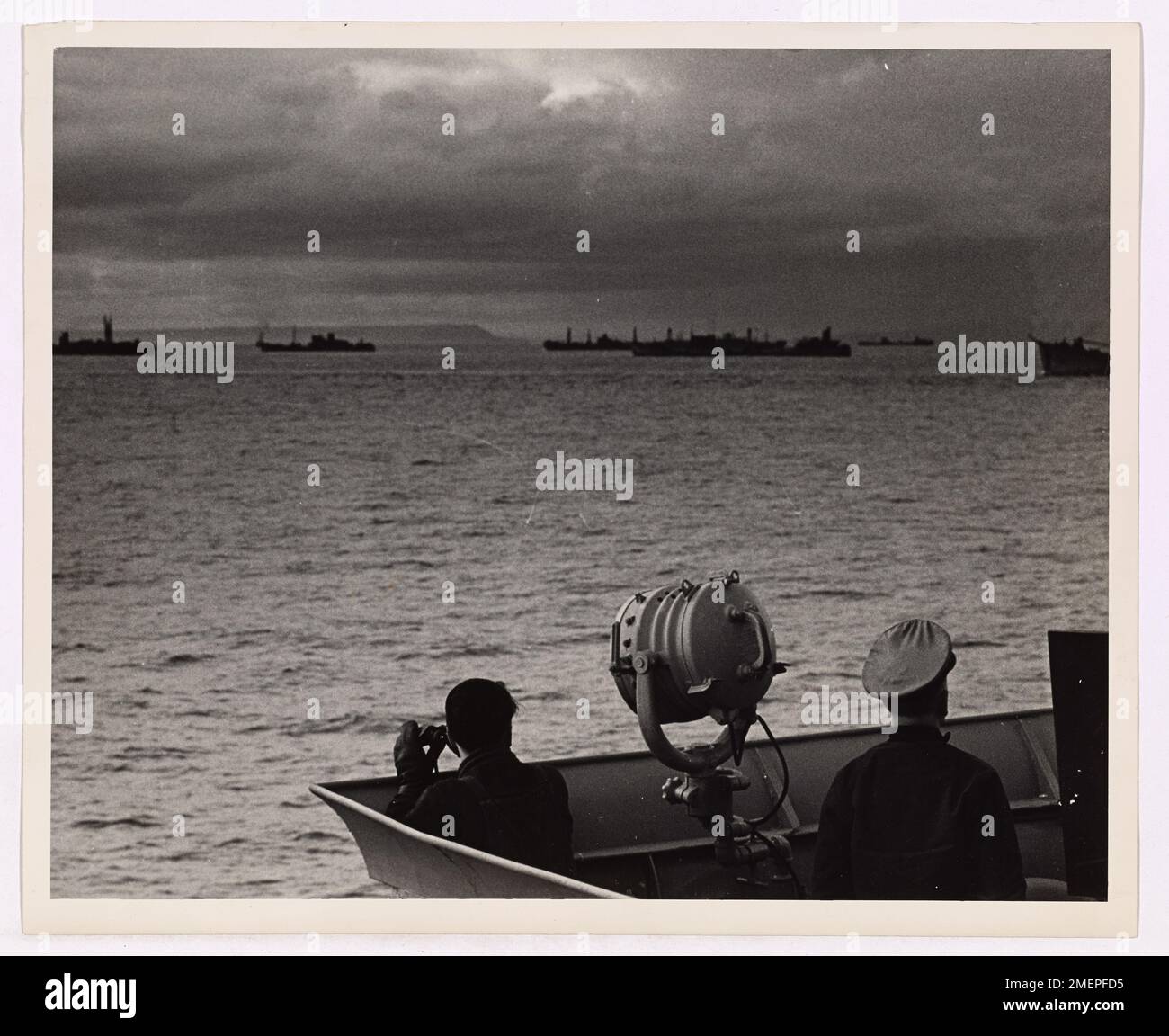 A convoy of military ships is seen from a vantage point, as men aboard ...