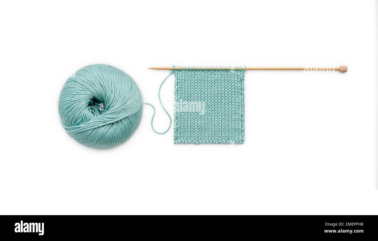 Ball of green mercerized cotton yarn and knitted sample on knitting ...