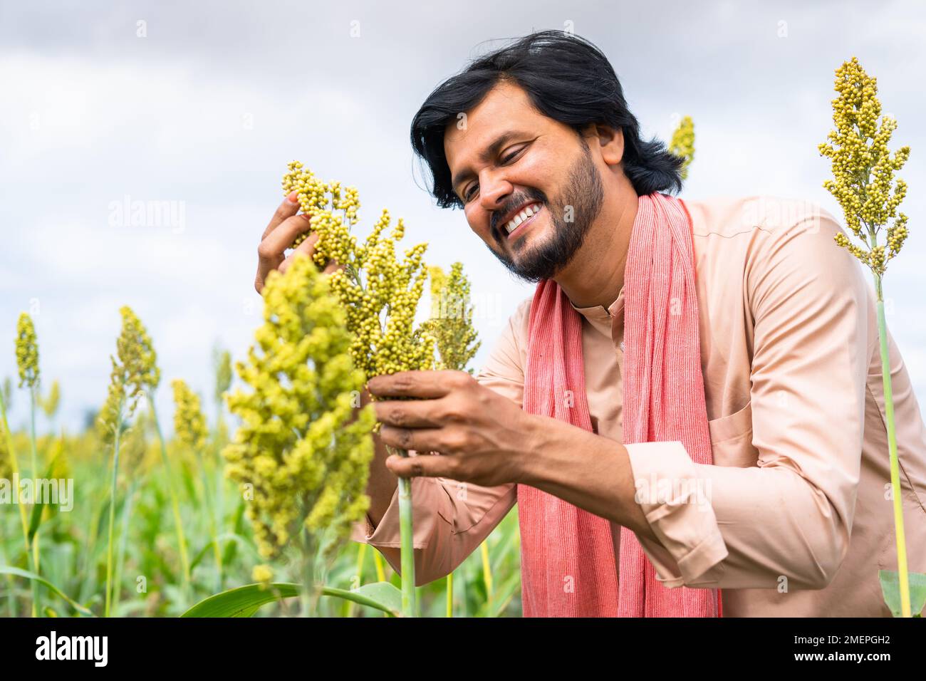 Happy smiling young farmer checking crop growth at farmland - concept ...