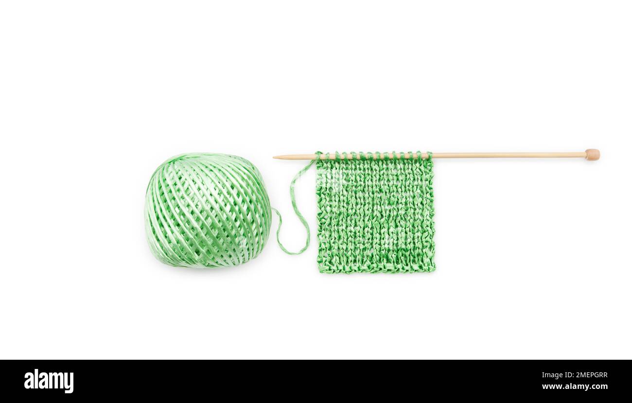 Ball of green string yarn and knitted sample on knitting needle Stock ...