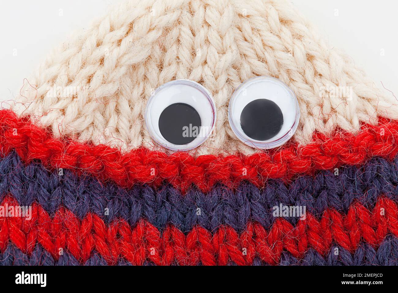 Eyes on knitted wool boiled egg cover Stock Photo - Alamy