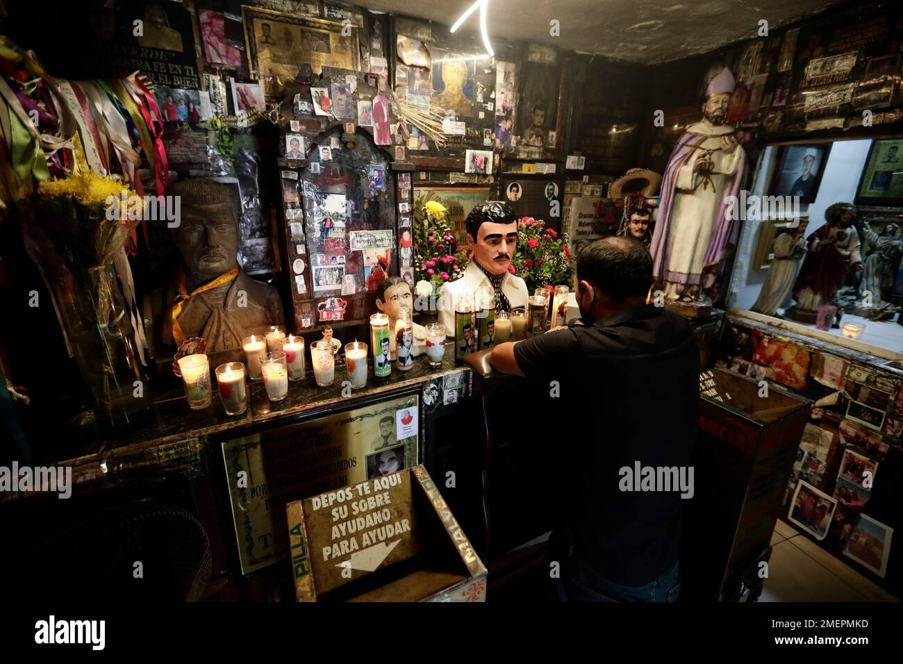 A man prays inside a shrine dedicated to the folk-saint Jesus Malverde ...