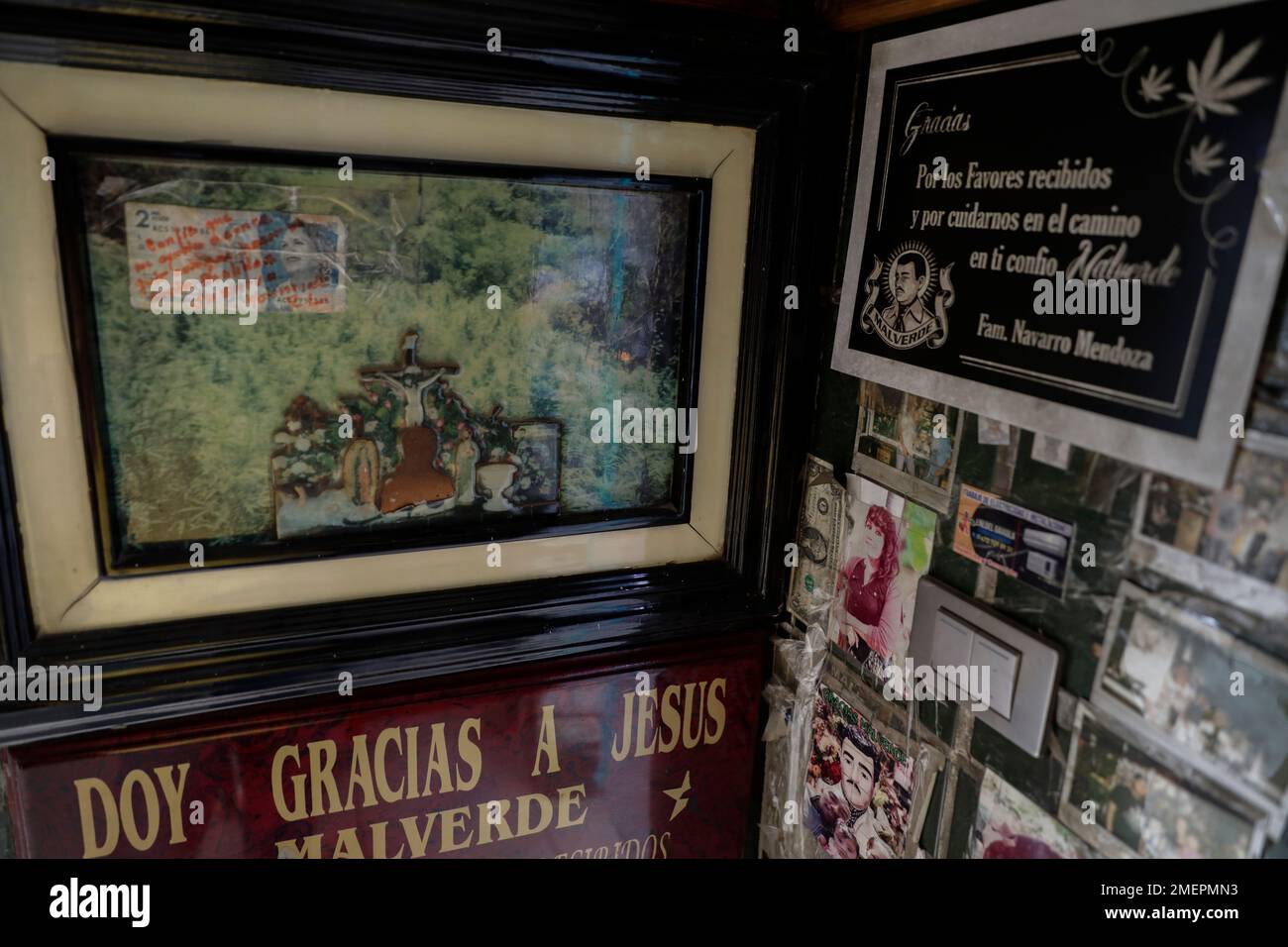 Picture and plaques with acknowledgments taped to the wall adorn a room ...