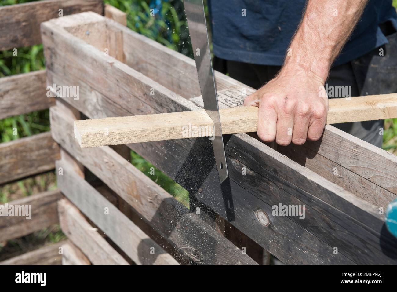 Sawing wood, constructing compost heap Stock Photo - Alamy