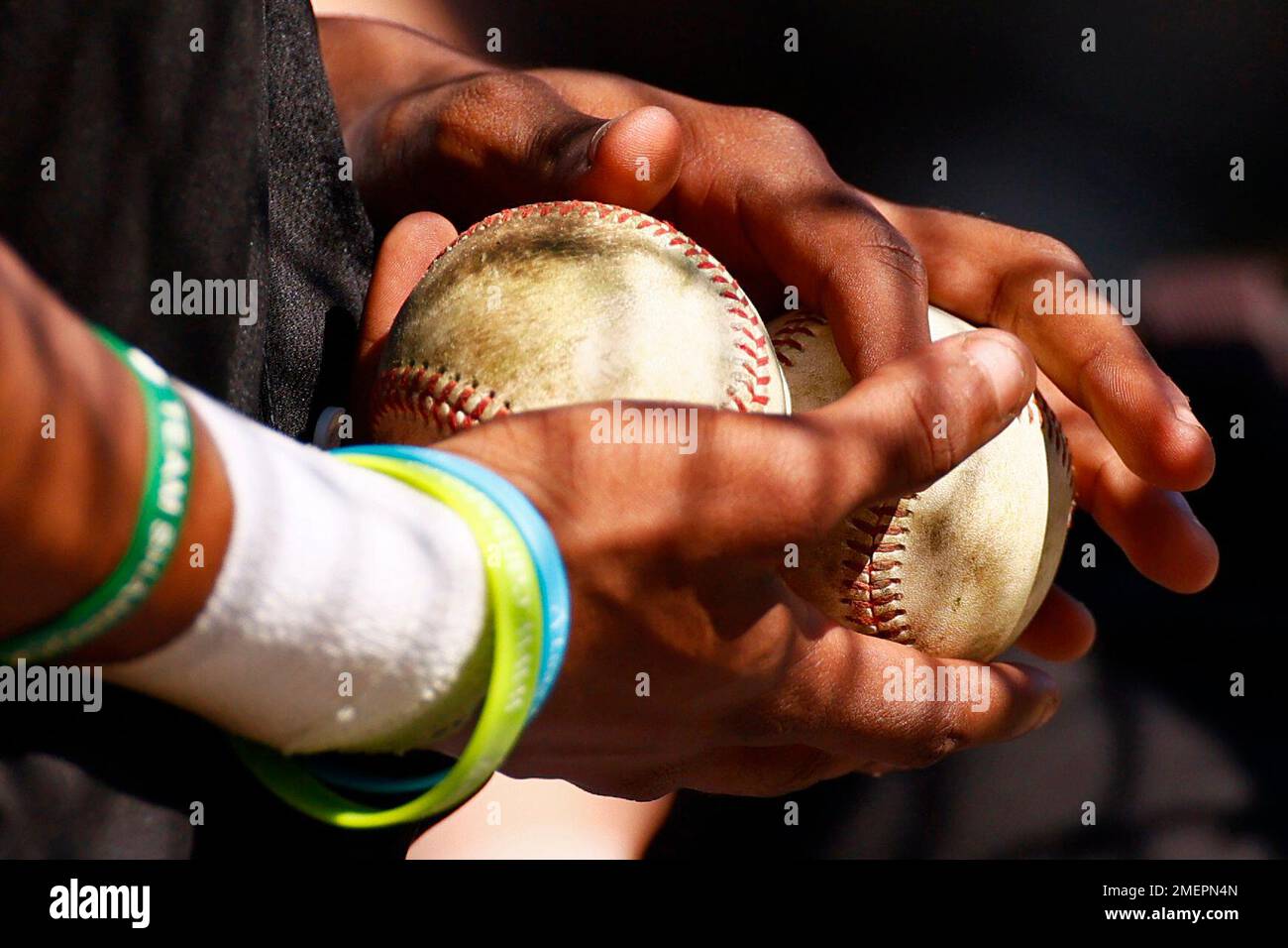 A Manhattan player holds baseball during an NCAA baseball game against ...