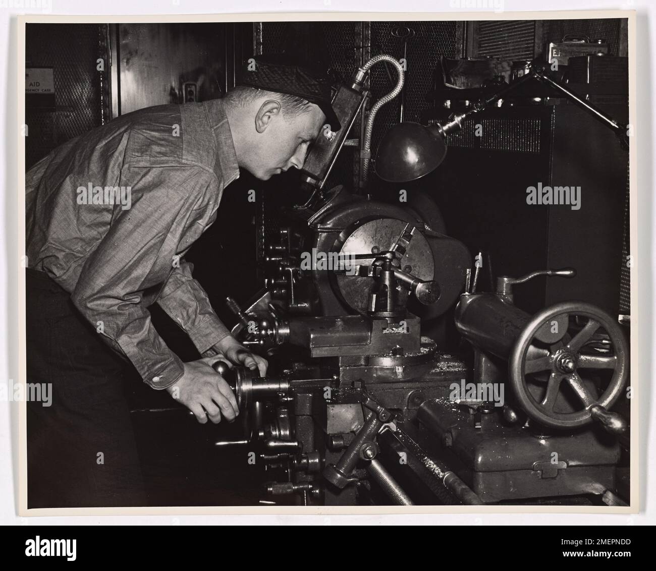 A U.S. Maritime Engineer Cadet operates a lathe onboard a ship, gaining ...