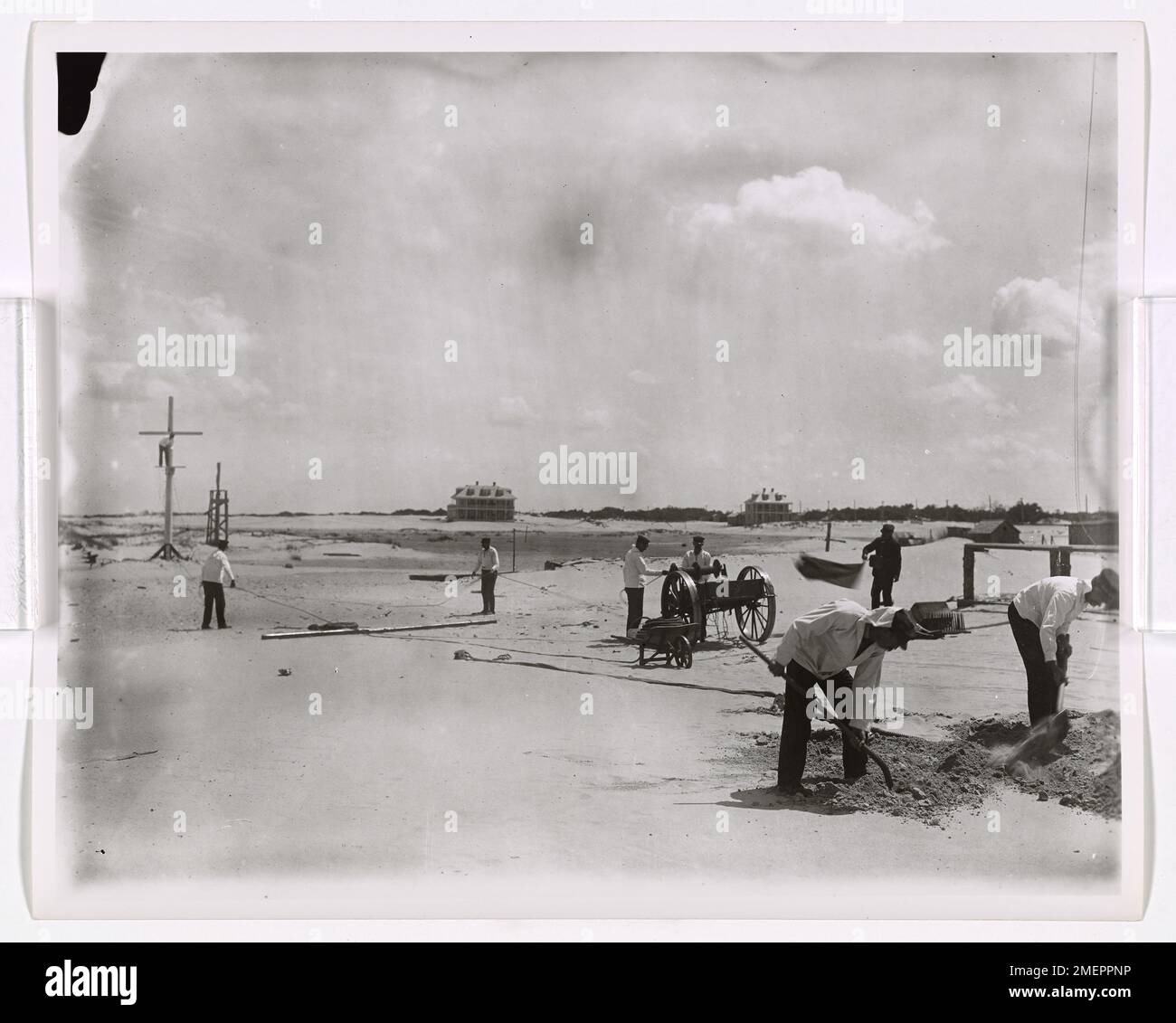 Photograph of Working on a Beach. This image depicts a group of men ...