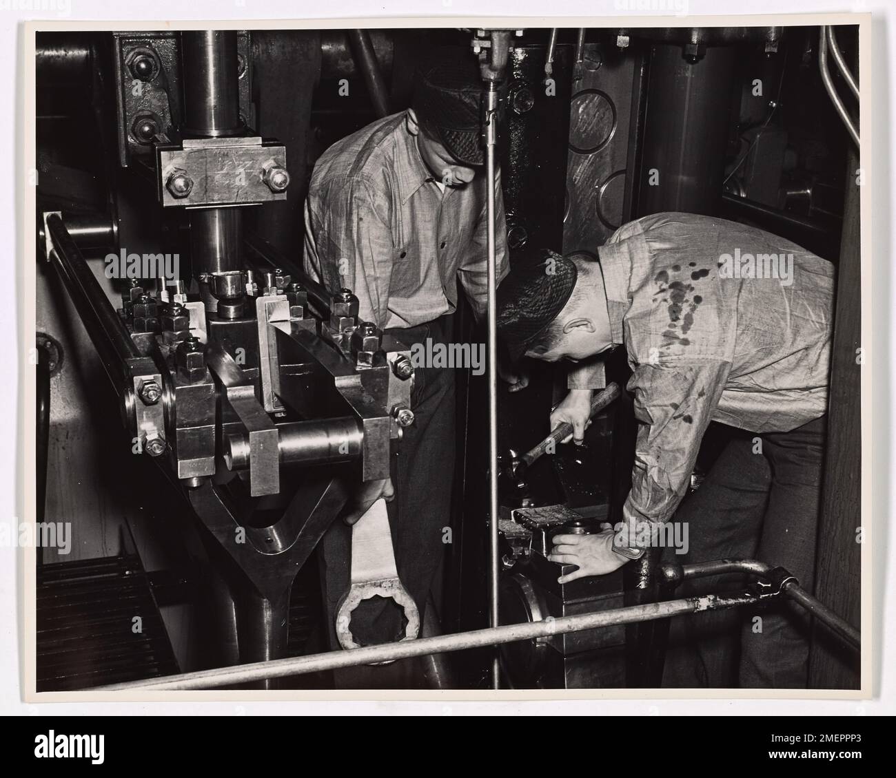 U.S. maritime engineer cadets work on a steam reciprocating engine as ...