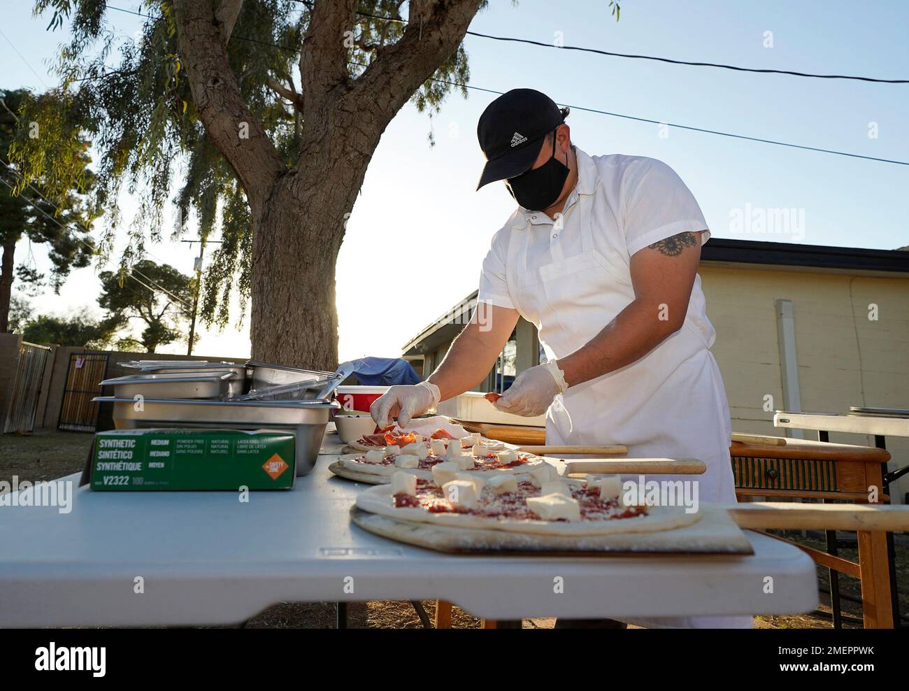 Chef Jose Hernandez preps several pizzas at his makeshift backyard ...