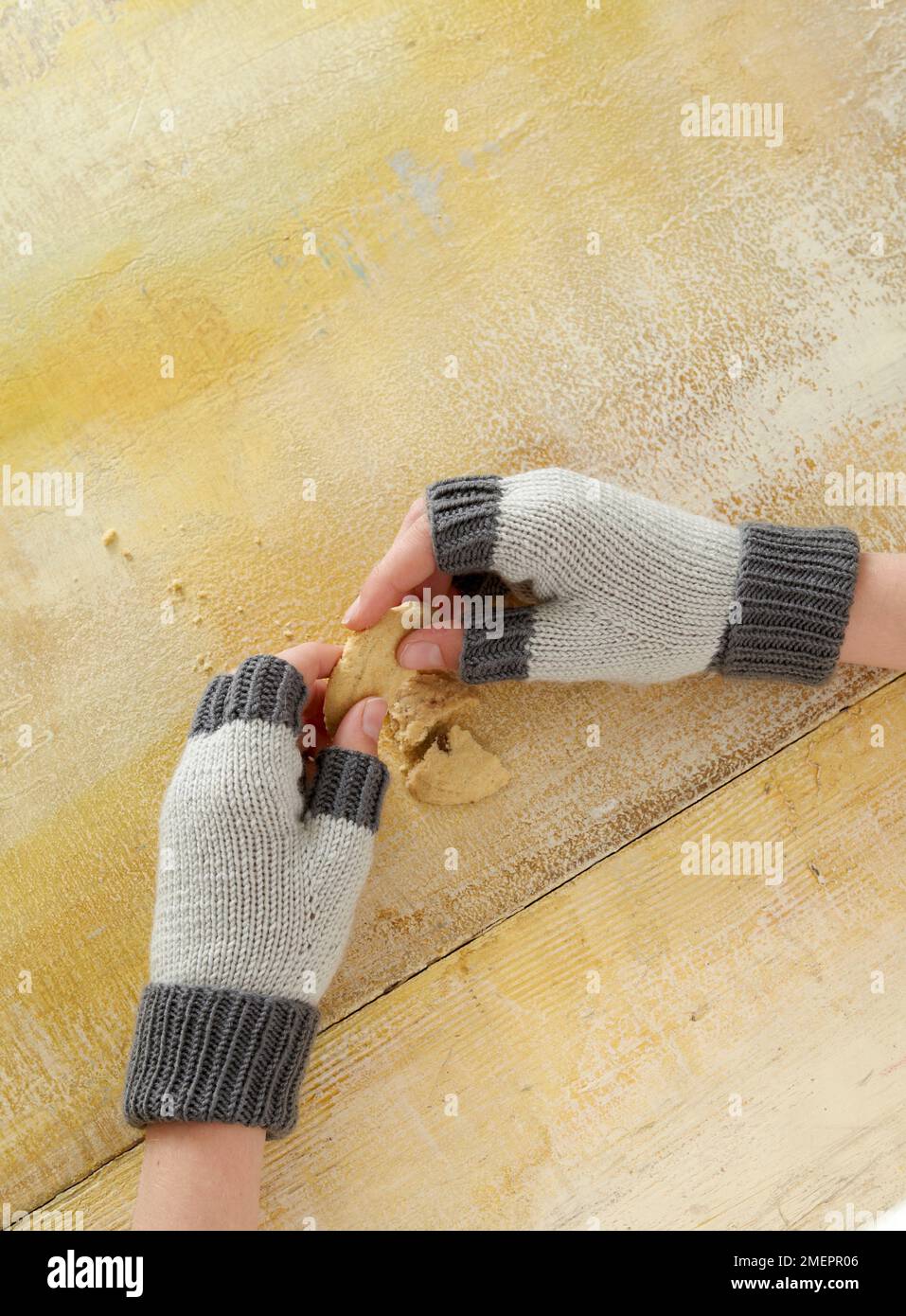Child's hands, wearing fingerless gloves, breaking biscuit Stock Photo ...