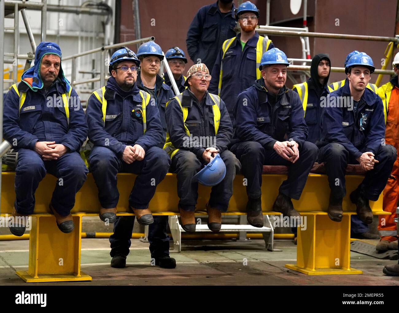 Workers look on as the first cut of steel for the Royal Navy frigate ...