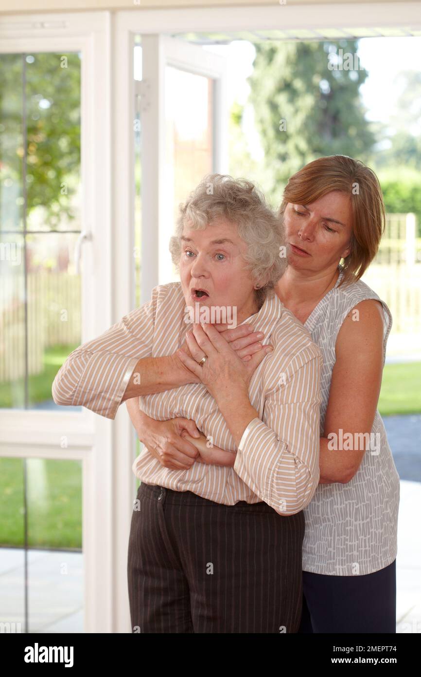 Assisting a woman who is choking Stock Photo - Alamy
